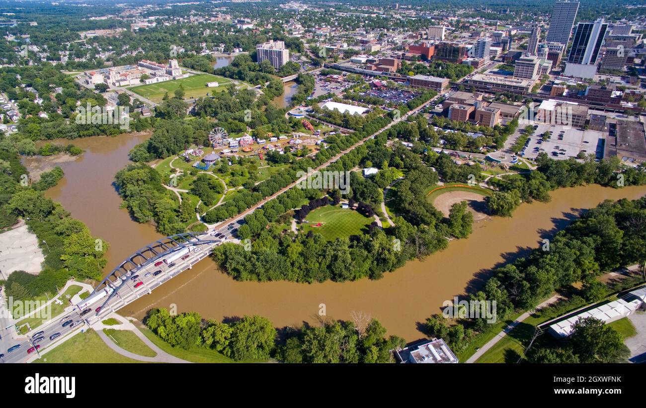 A bridge crosses a brown muddy river into a large city in an aerial ...