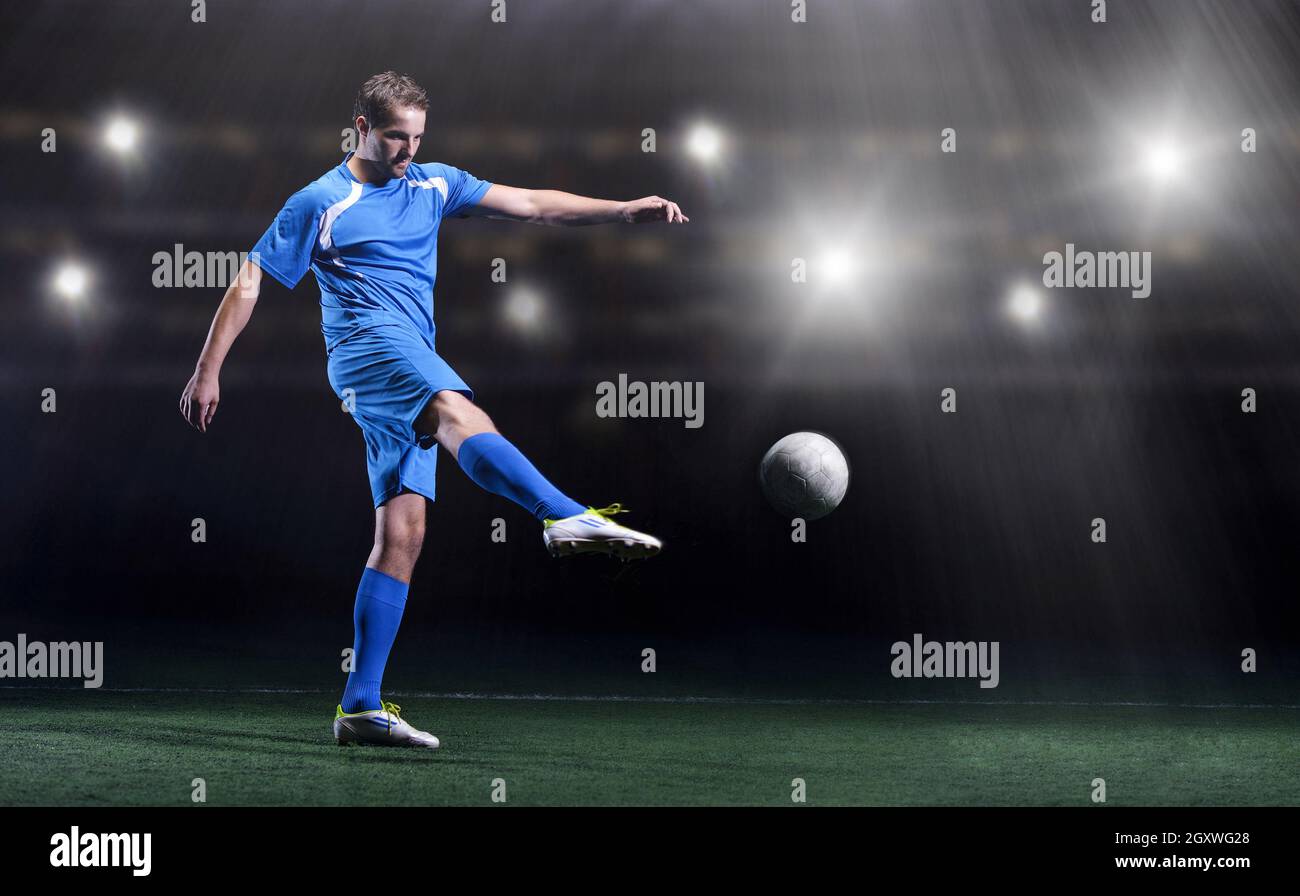 soccer player doing kick with ball on football stadium field isolated ...