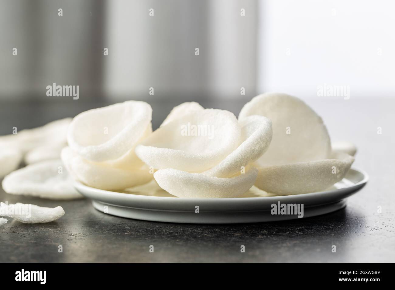 Puffed white snack chips. White potato chips on black table Stock Photo ...