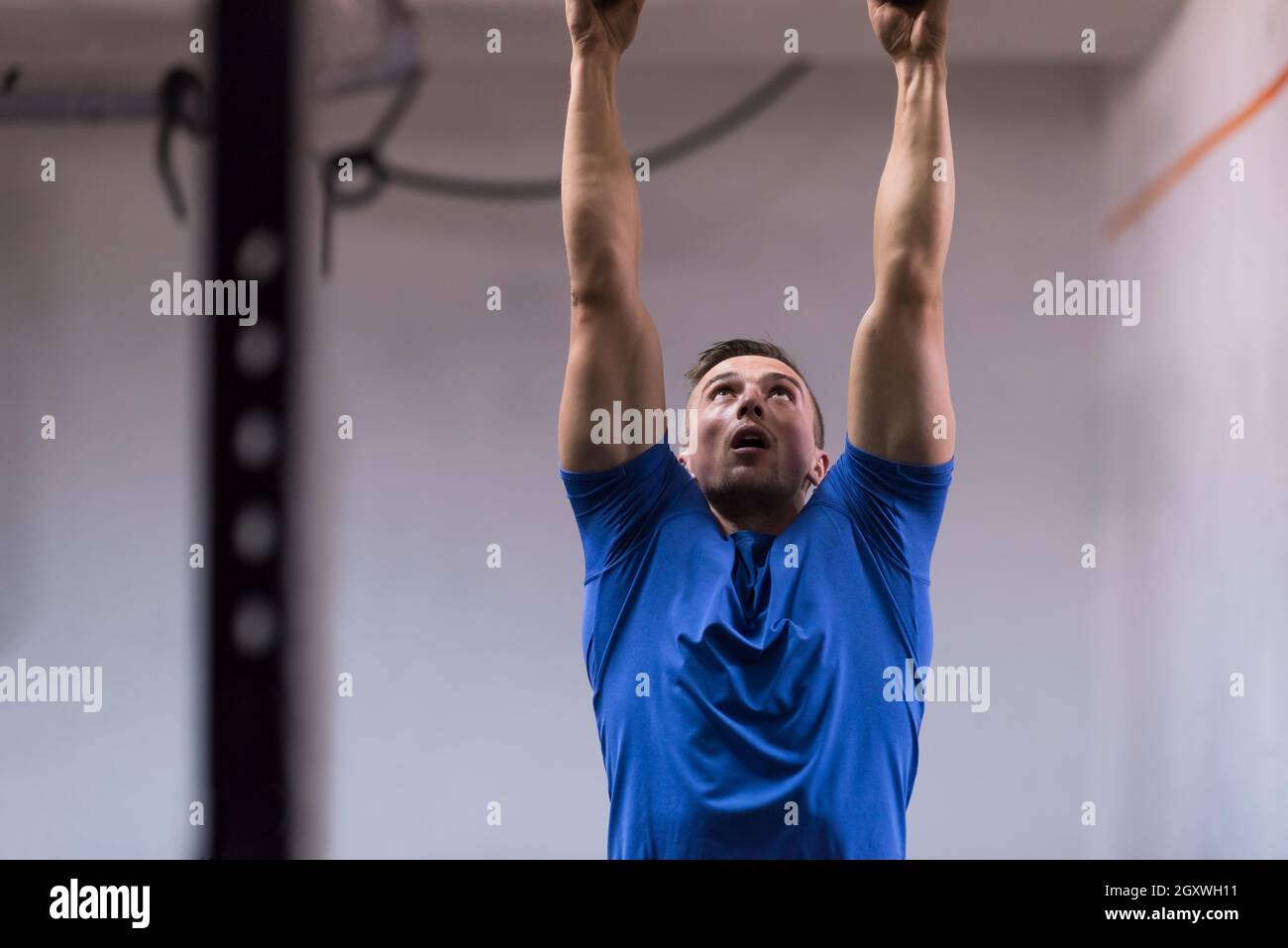 Fitness handsome man doing dipping exercise using rings in the gym ...