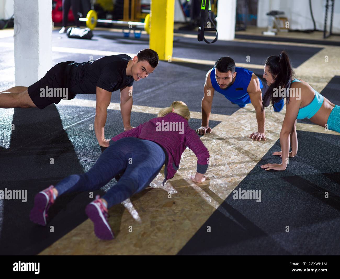 group of young healthy people doing pushups at crossfitness gym Stock ...