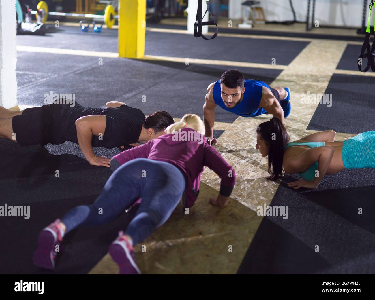 group of young healthy people doing pushups at fitness gym Stock Photo ...