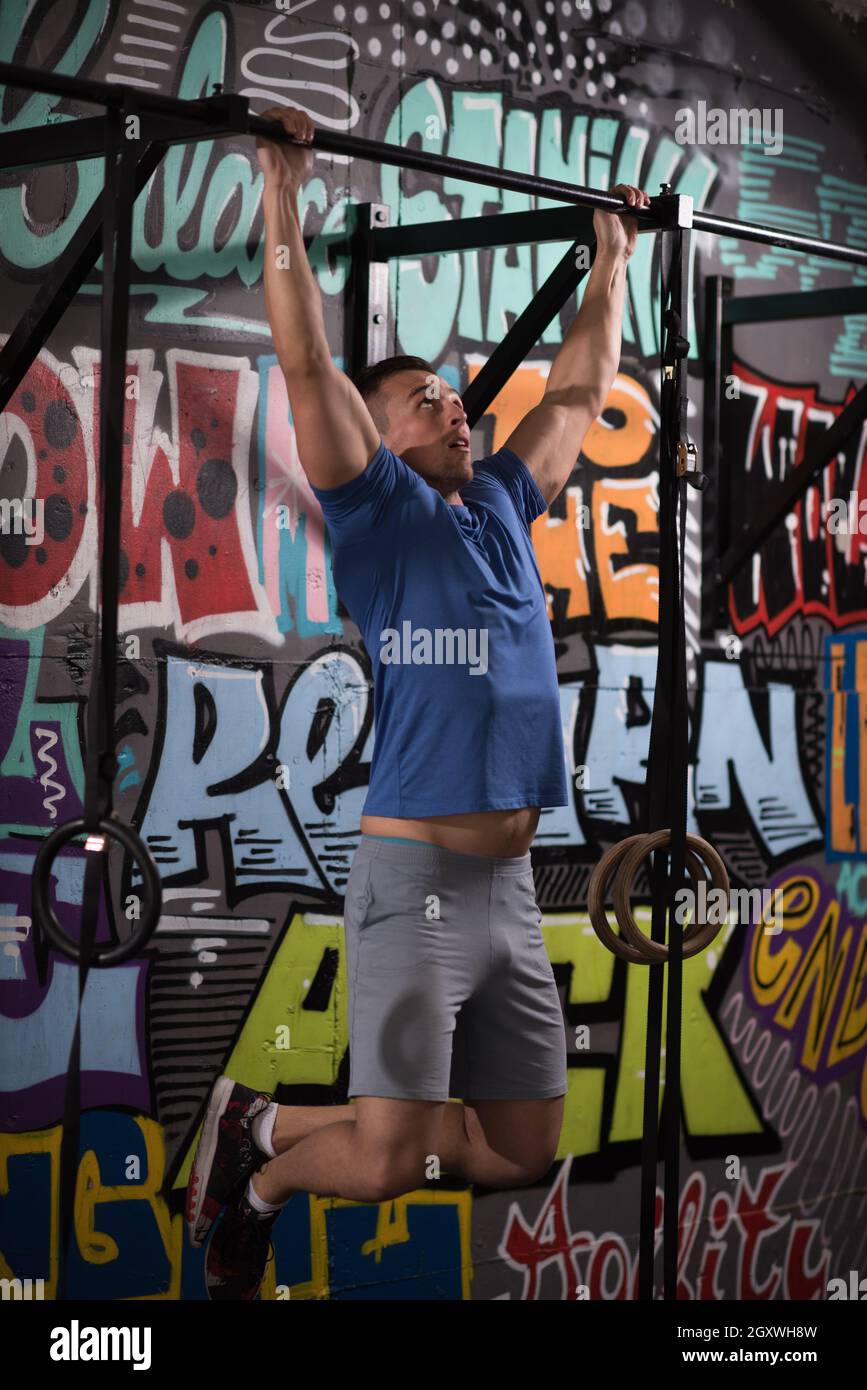 strong young man doing pull ups on a bar in a gym Stock Photo - Alamy