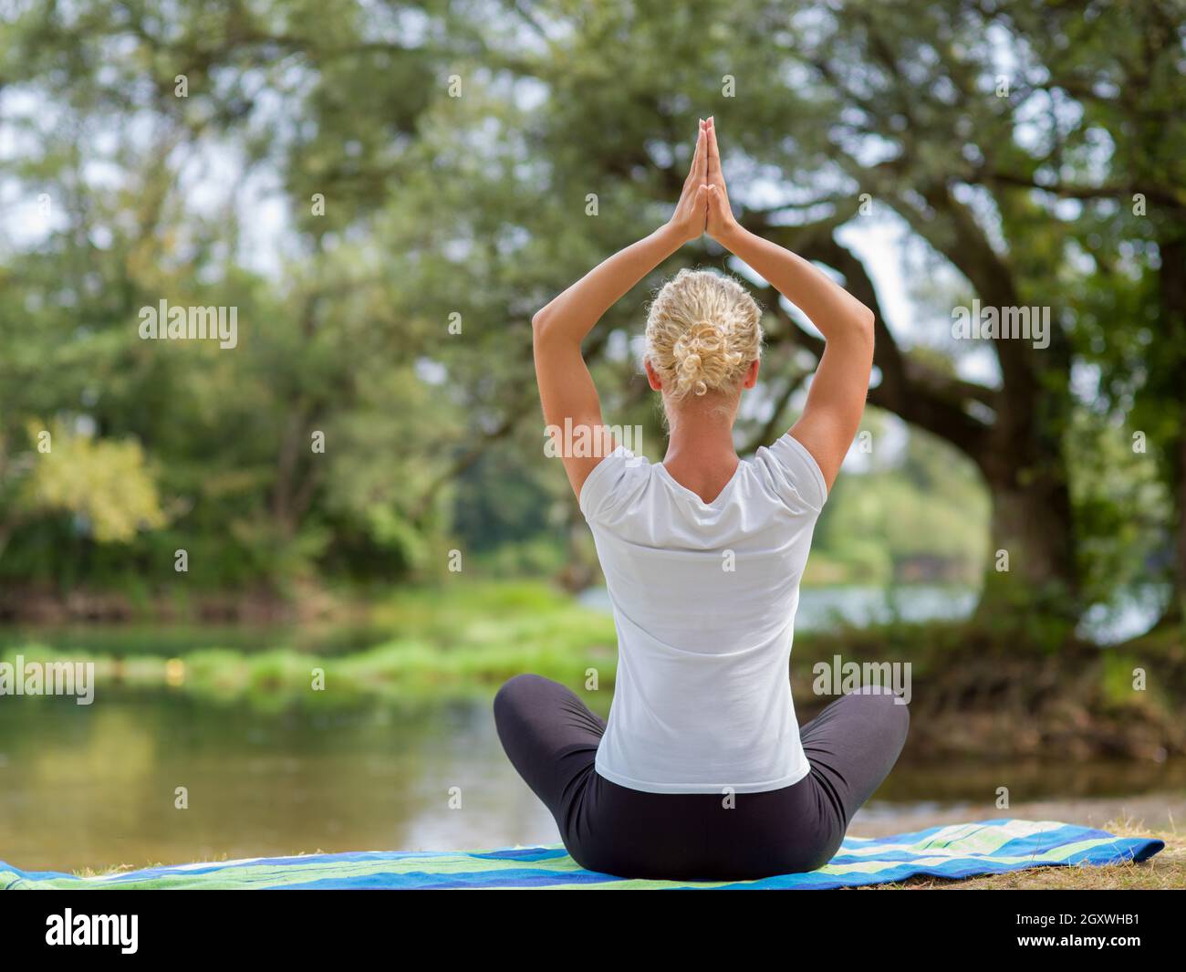 healthy woman relaxing while meditating and doing yoga exercise in the ...