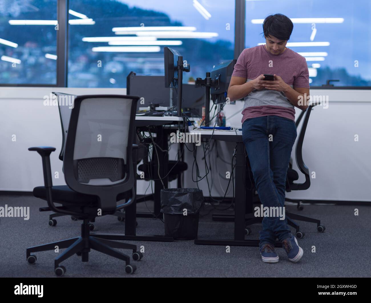 young indian male software developer using mobile phone writing ...