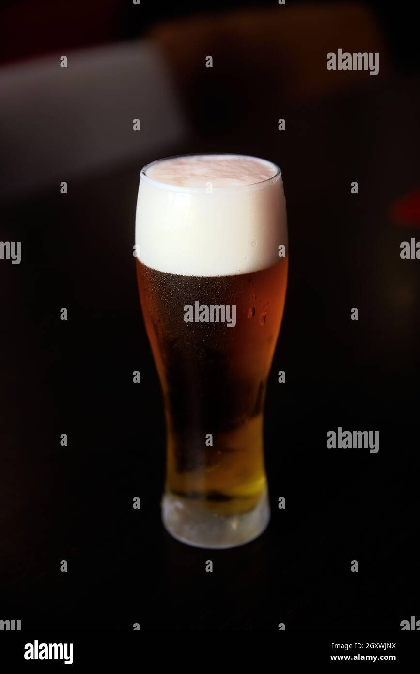 Fresh cold beer, glass of beer on a table in a bar on blurred bokeh ...
