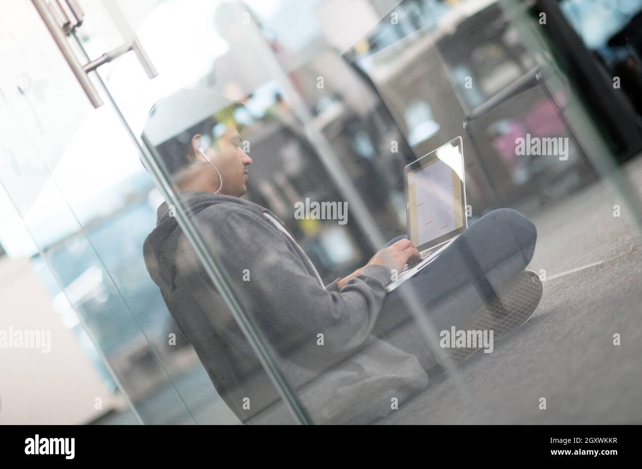 young indian software developer man using laptop computer writing programming code while sitting ...