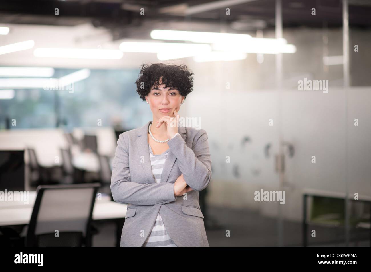 Portrait of successful female software developer with a curly hairstyle ...