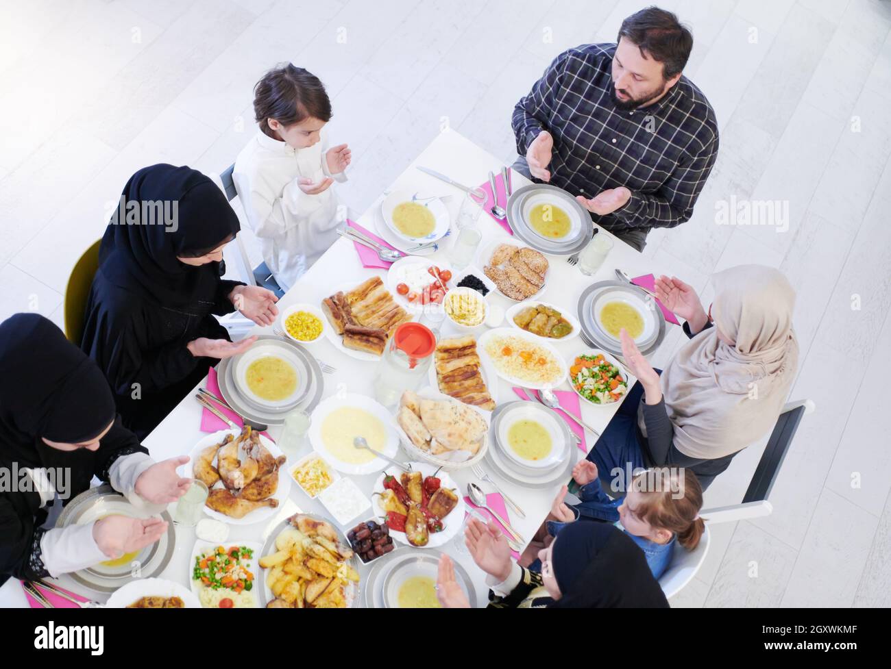 Eid Mubarak Muslim people praying before iftar dinner. Eating ...