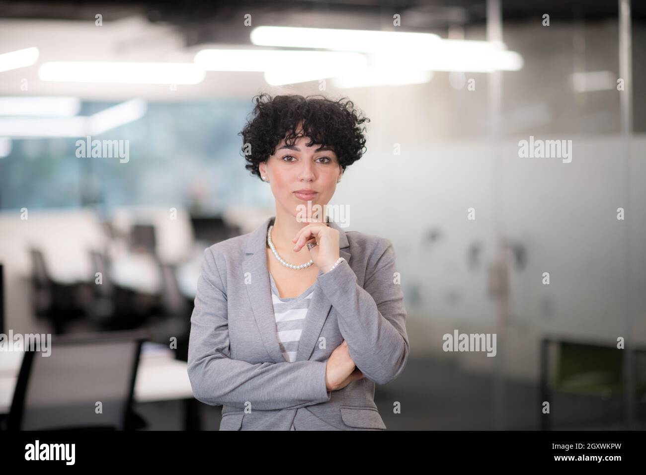 Portrait of successful female software developer with a curly hairstyle ...