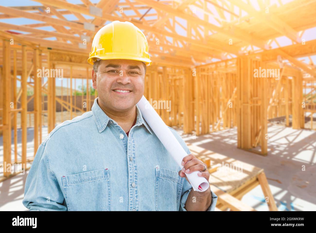 Hispanic Male Contractor with Blueprint Plans Wearing Hard Hat At ...