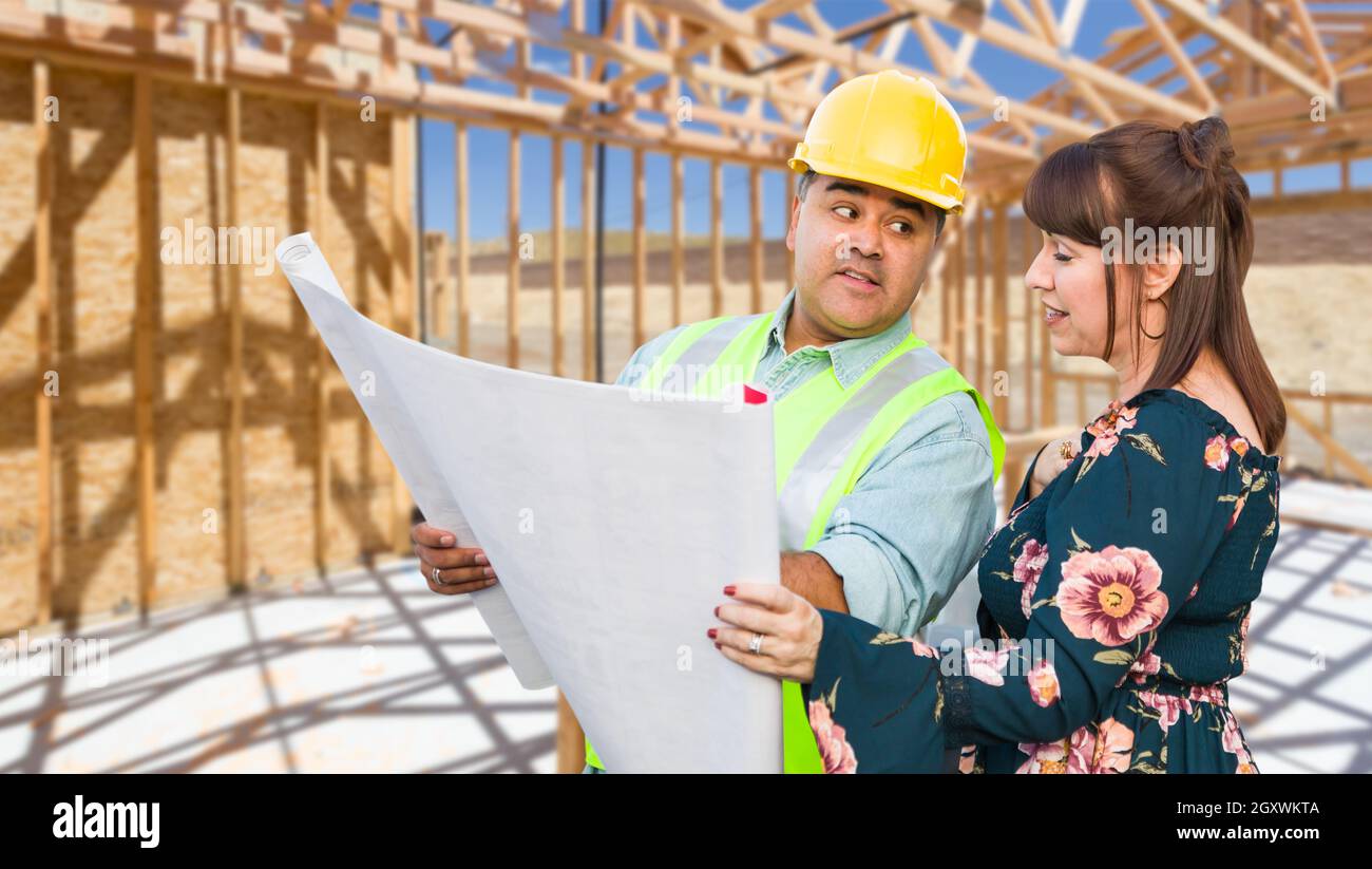 Hispanic Male Contractor Talking with Female Client Over Blueprint ...