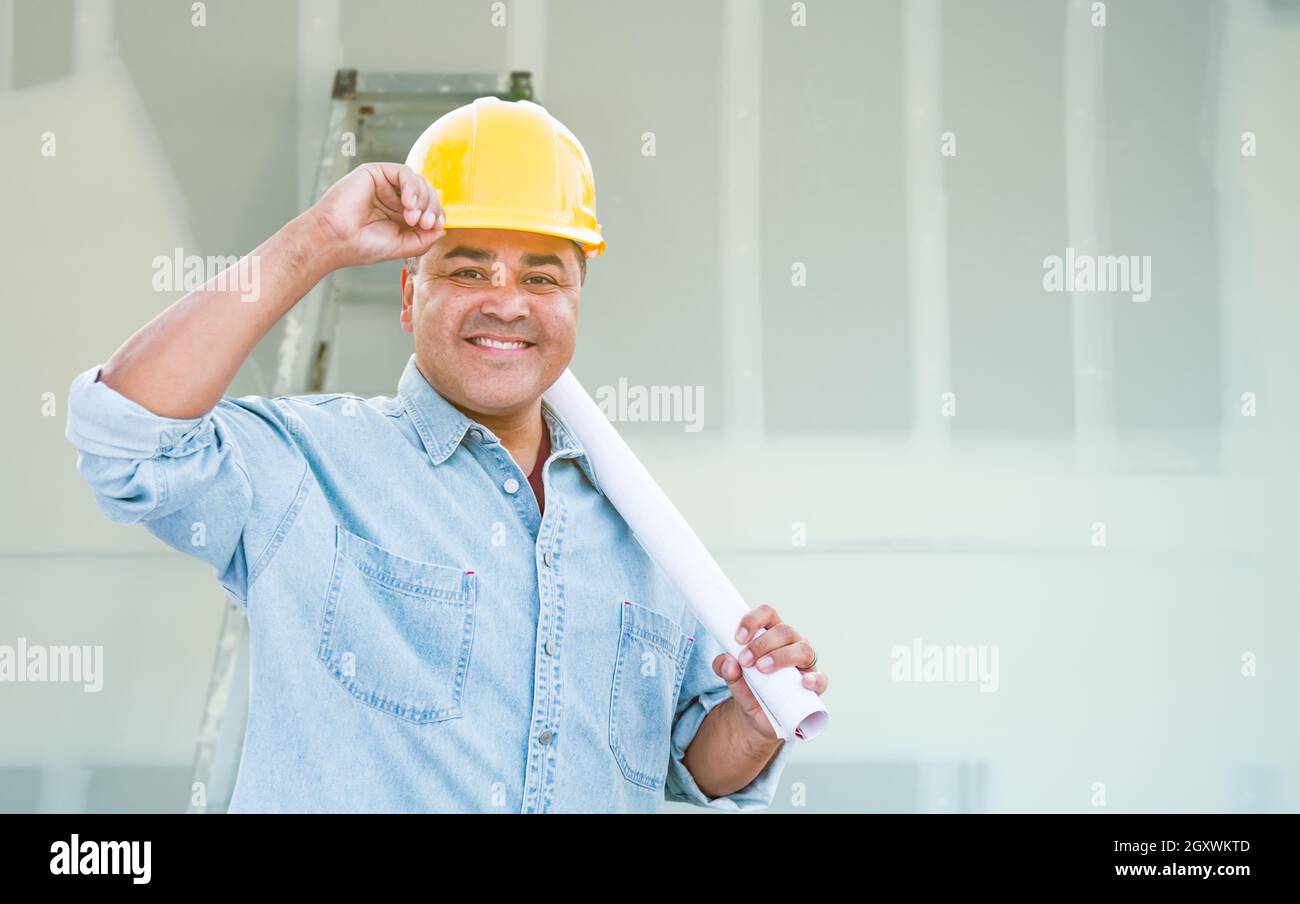 Hispanic Male Contractor with Blueprint Plans Wearing Hard Hat In Front ...