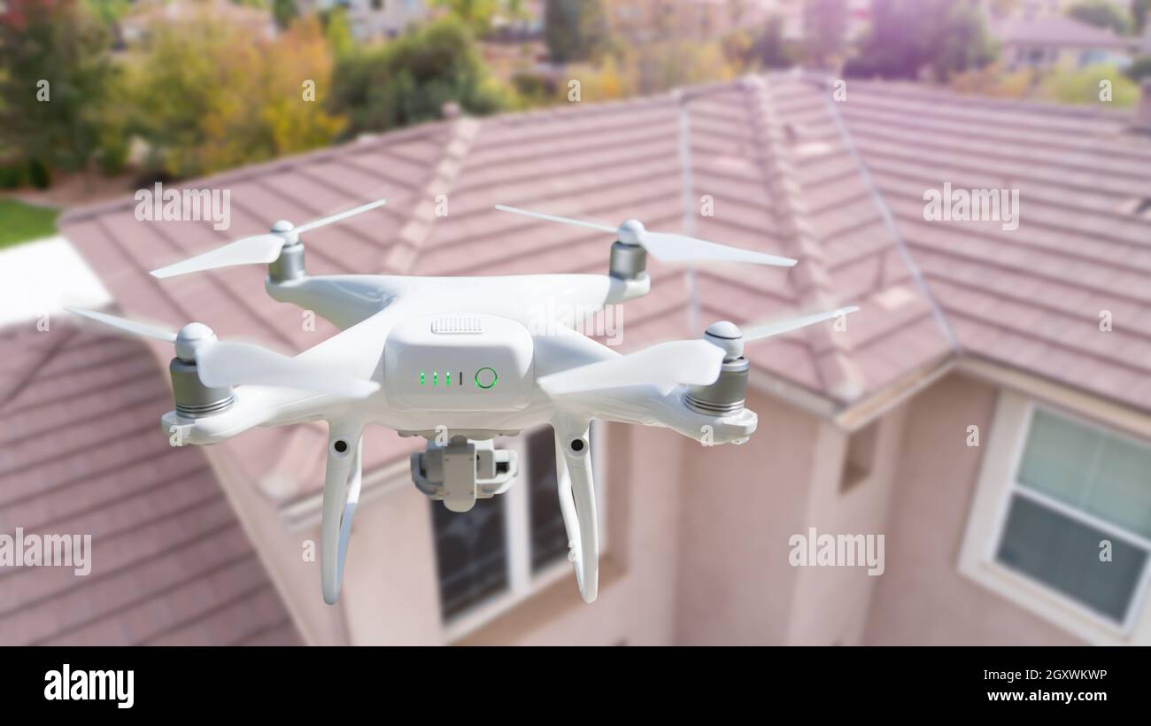 Unmanned Aircraft System (UAV) Quadcopter Drone In The Air Over House ...