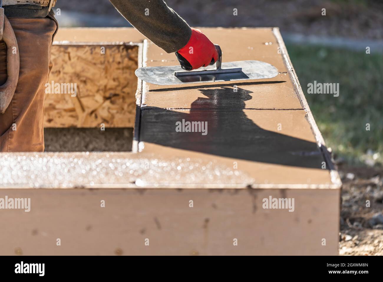 Construction Worker Using Trowel On Wet Cement Forming Coping Around ...
