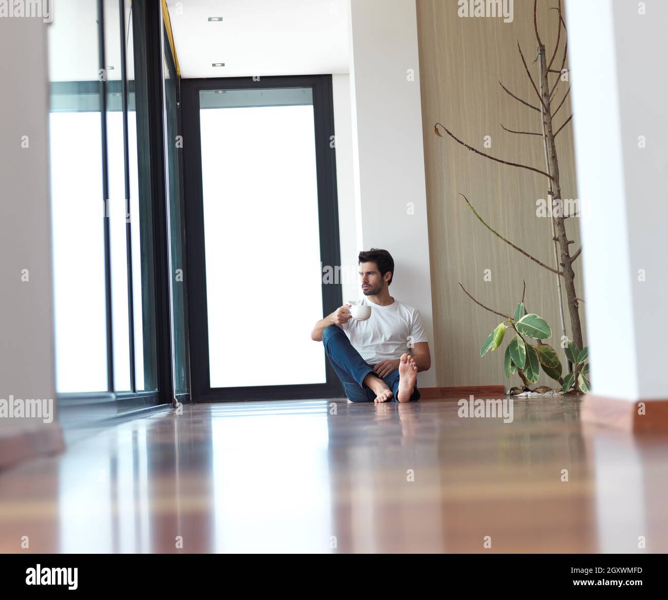 relaxed young man drink first morning coffee at modern home indoors ...