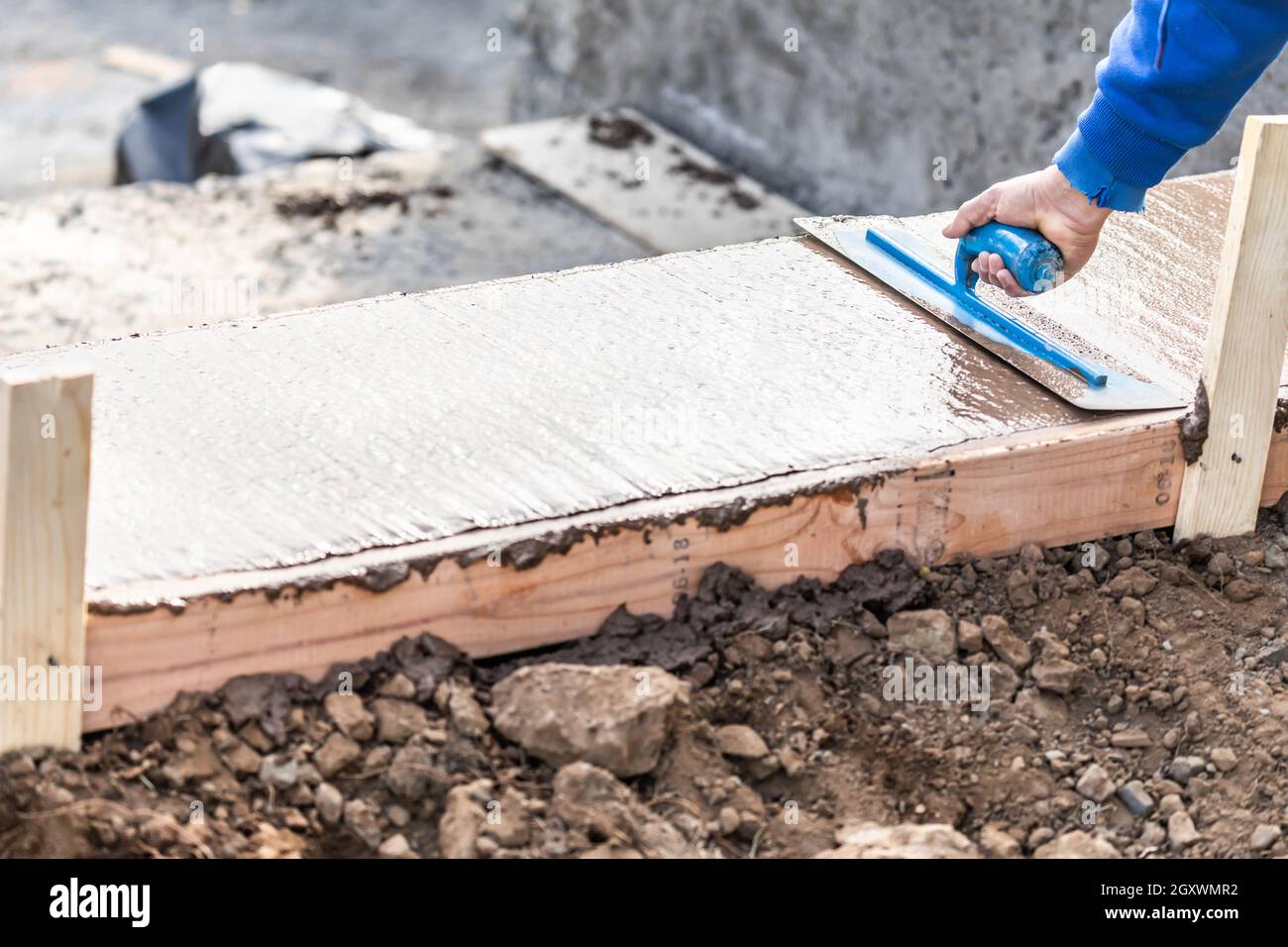 Construction Worker Using Trowel On Wet Cement Forming Coping Around ...