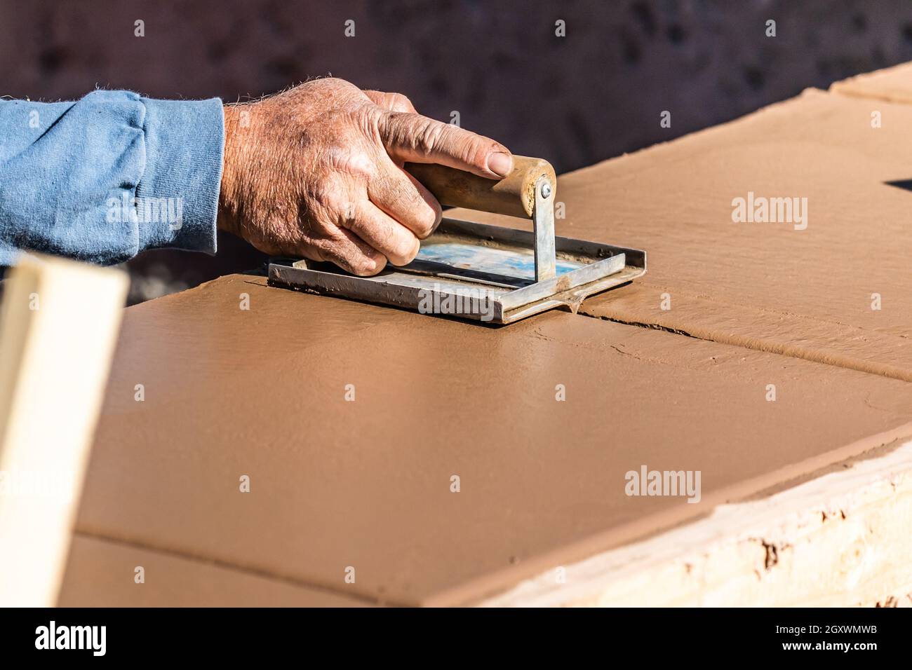 Construction Worker Using Hand Groover On Wet Cement Forming Coping ...
