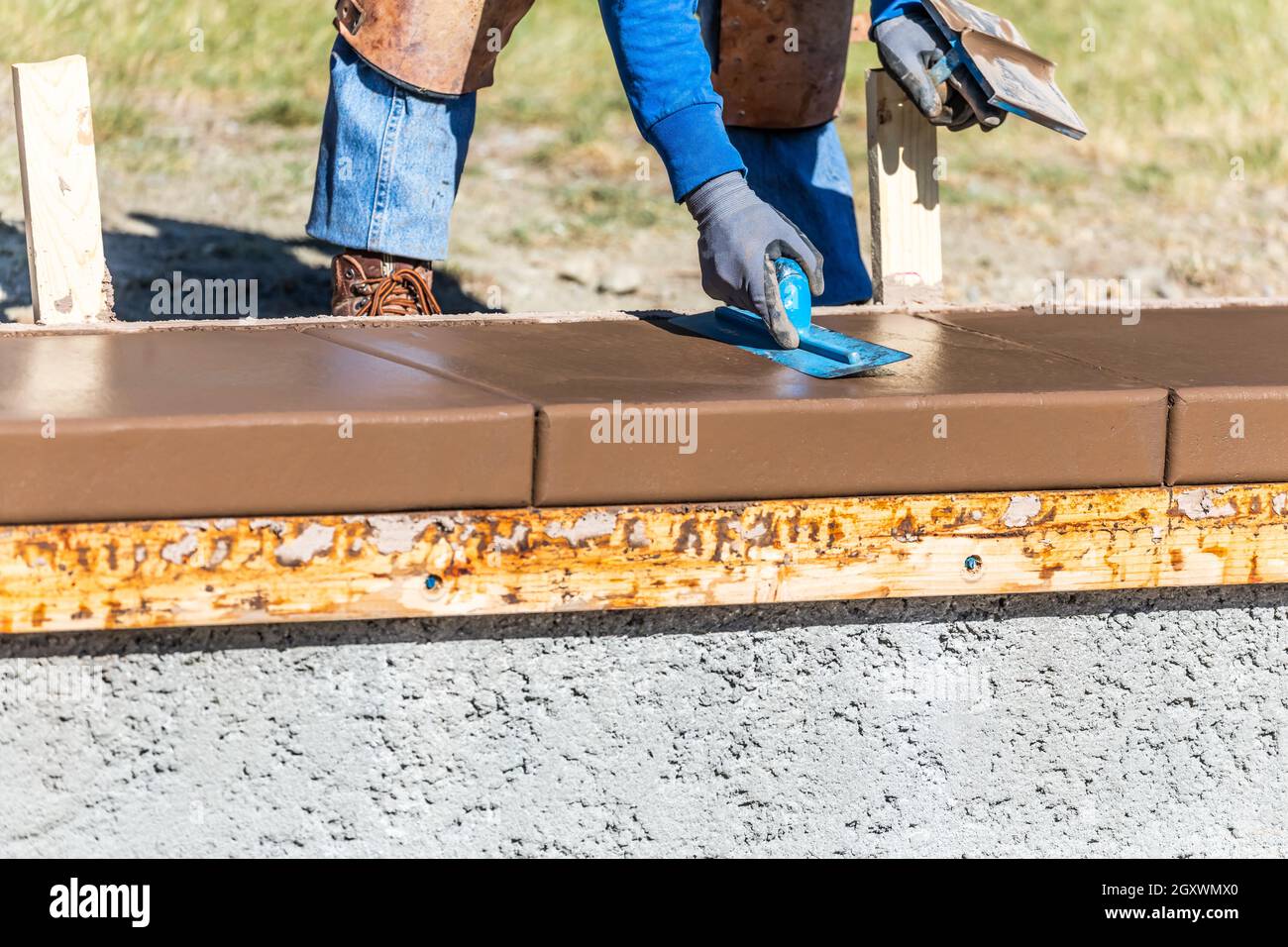 Construction Worker Using Trowel On Wet Cement Forming Coping Around ...