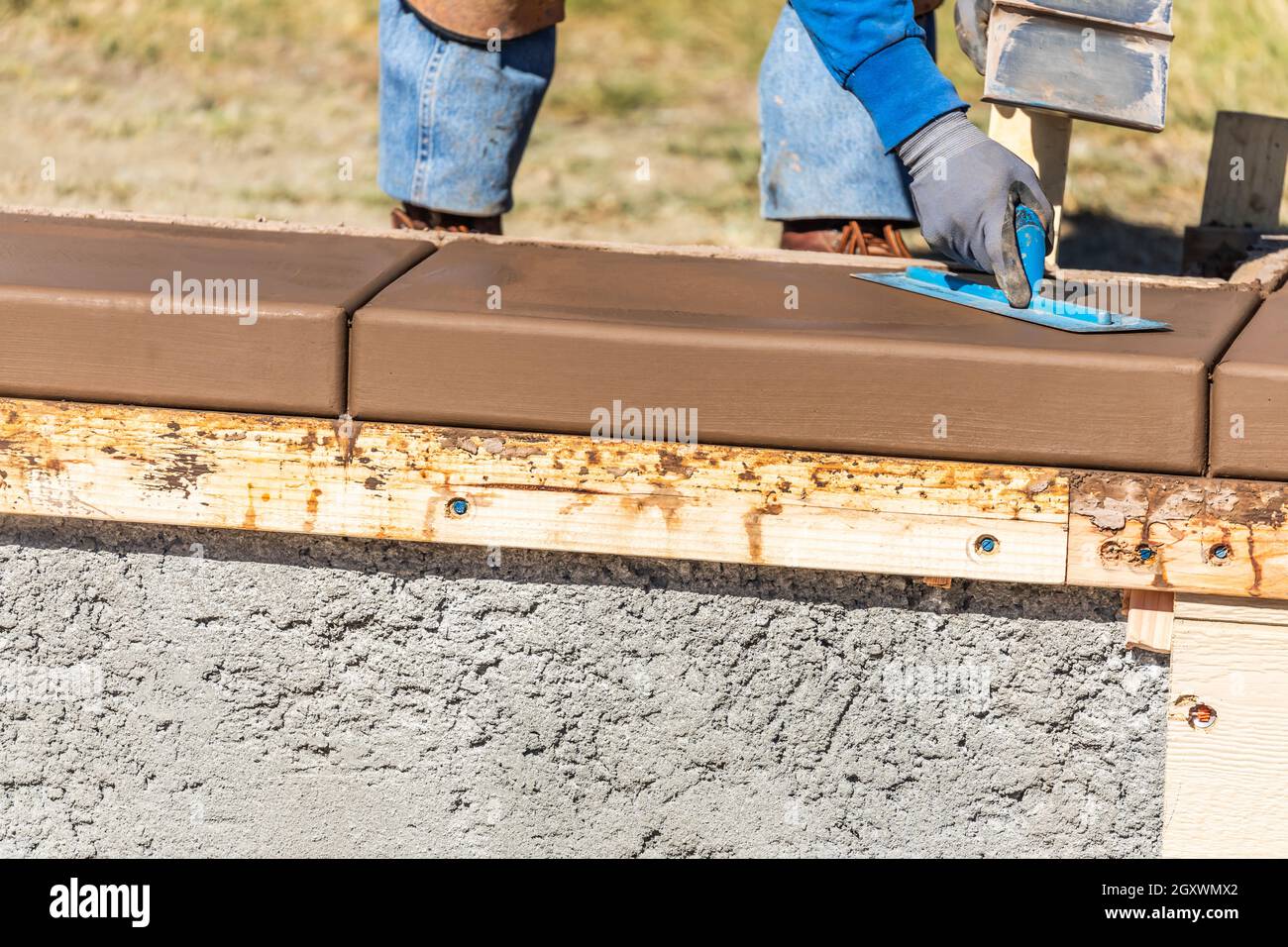 Construction Worker Using Trowel On Wet Cement Forming Coping Around ...