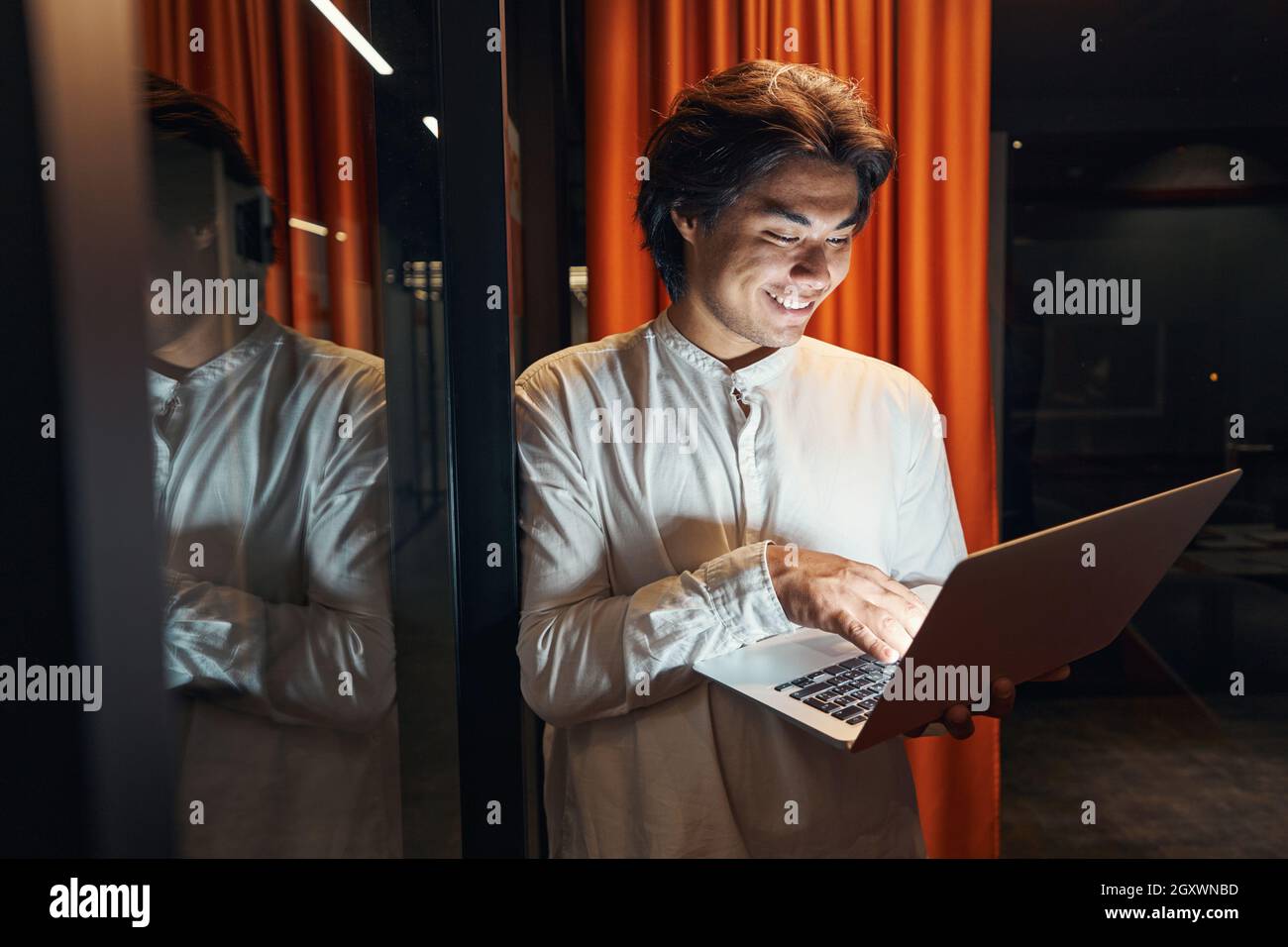 Man looking at screen of laptop with smile Stock Photo - Alamy