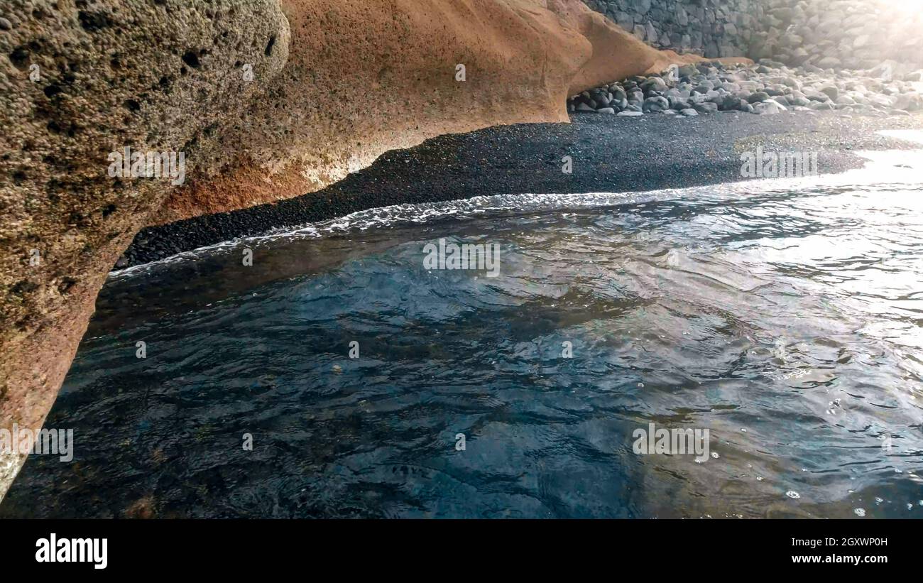 Beautiful landscape of high cliffs on volcanic sea beach with black ...