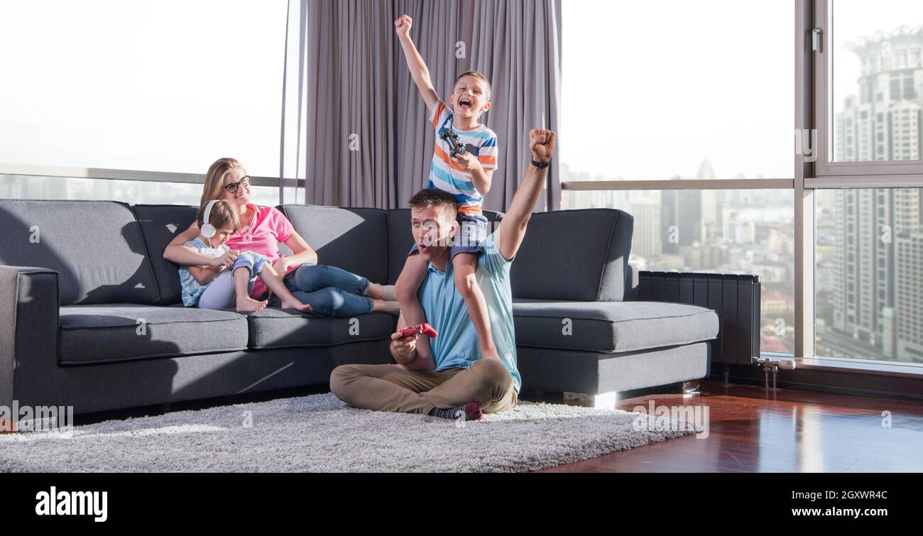 Happy family. Father, mother and children playing a video game Father ...