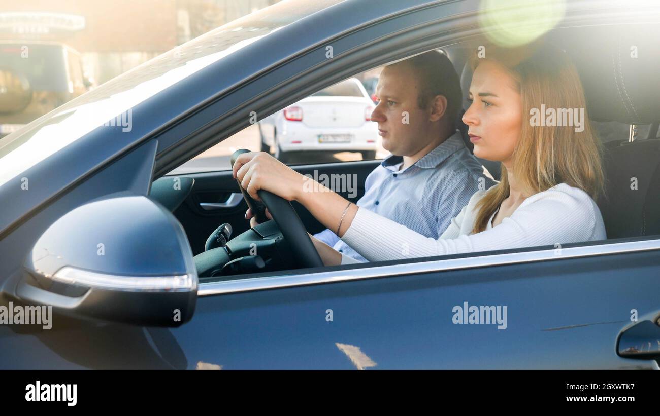 Portrait Of Young Concentrated Woman Driving A Car With Her Young