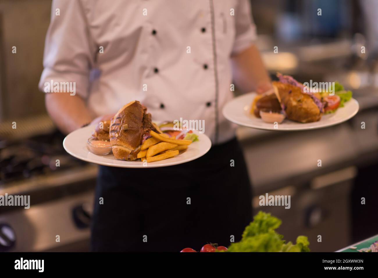 young Chef presenting dishes of tasty meals in commercial kitchen Stock ...