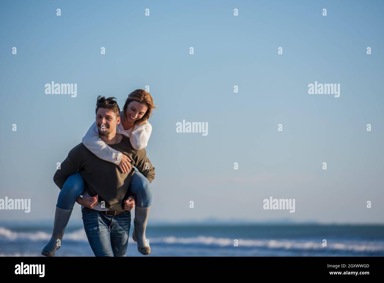 Men Giving Piggy Back Rides to his girlfriend At Sunset By The Sea, autumn time Stock Photo - Alamy