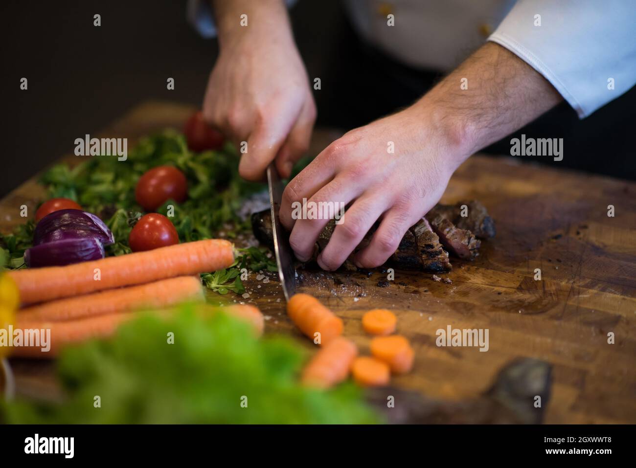 closeup of Chef hands in hotel or restaurant kitchen preparing beef ...