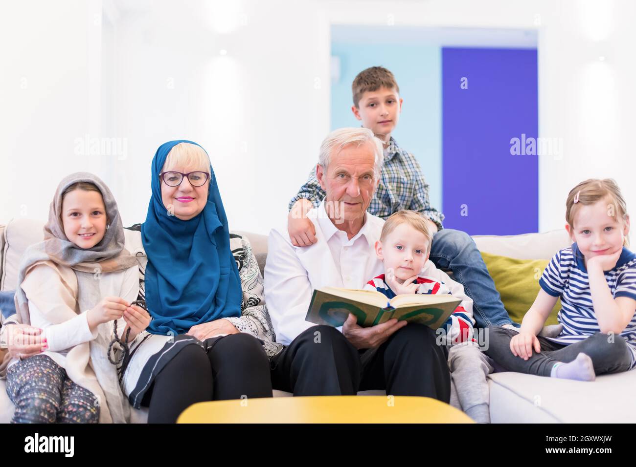 modern muslim family grandparents with grandchildren reading Quran and ...