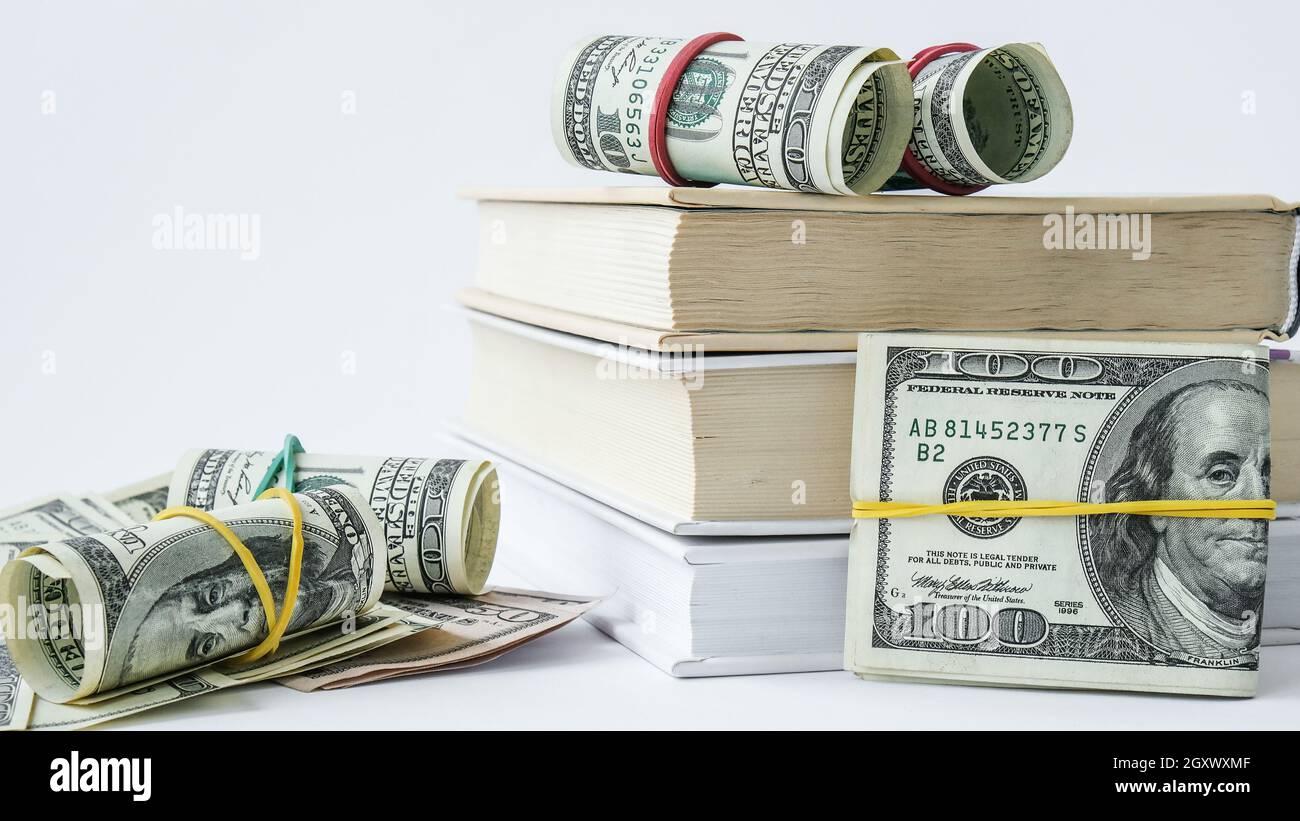 Knowledge leads to wealth. Stack of books with dollars. Concept of ...