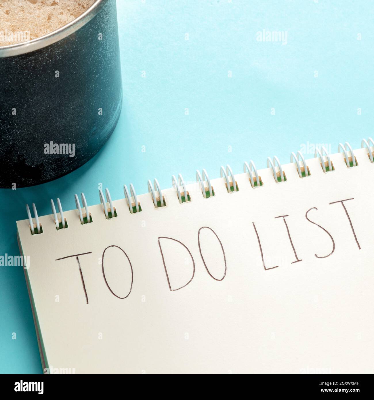 To do list square shot with handwriting in a notepad and a coffee mug ...