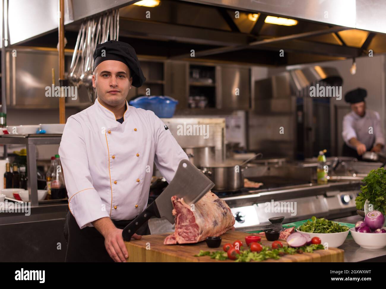 chef using ax while cutting big piece of beef on wooden board in ...