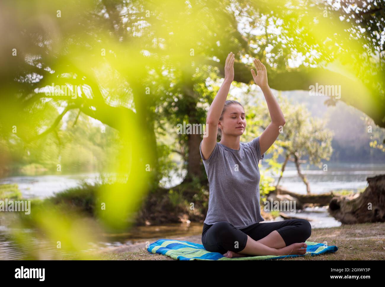 healthy woman relaxing while meditating and doing yoga exercise in the ...