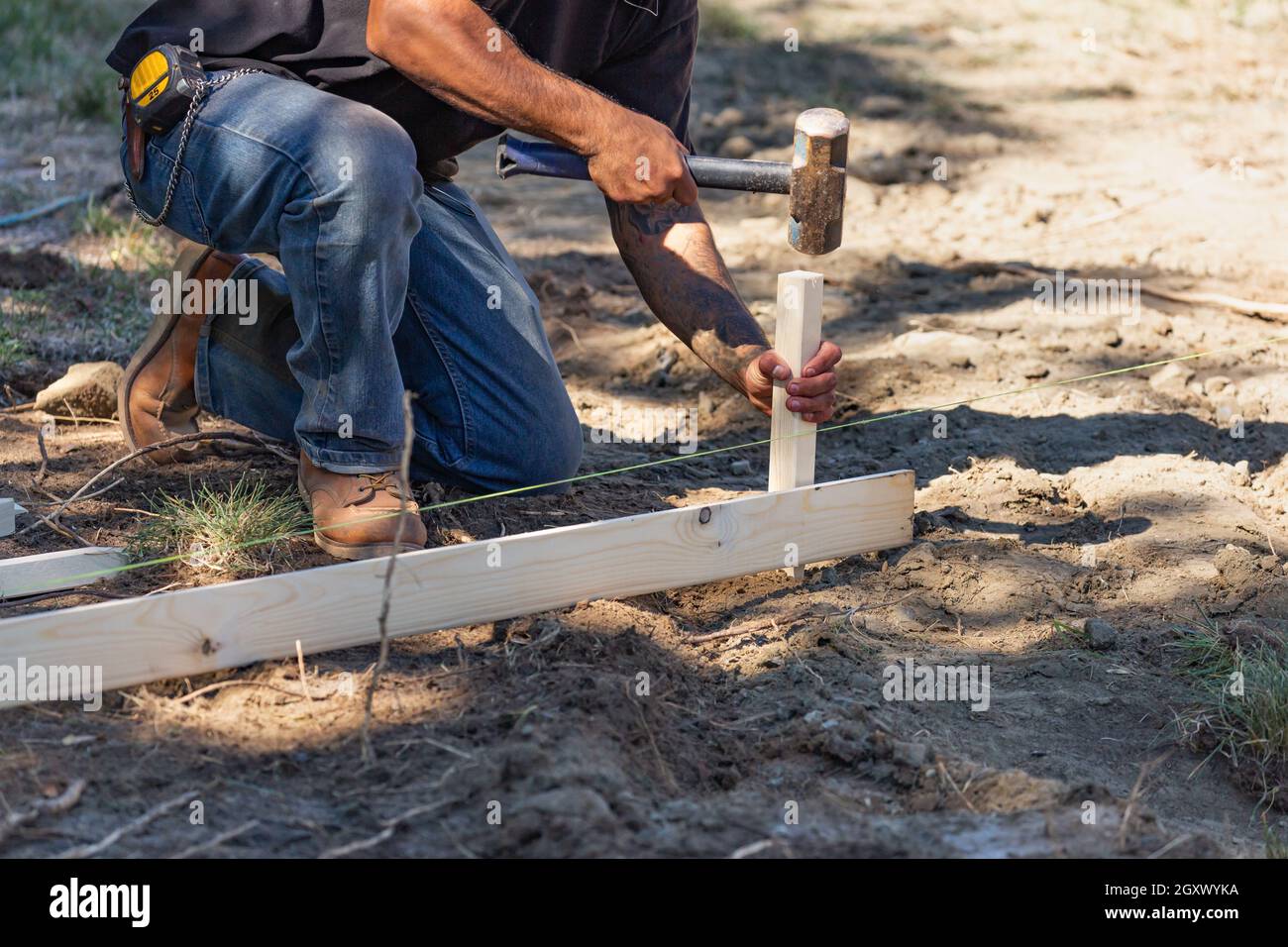 Worker Installing Stakes and Lumber Guides At Construction Site Stock ...