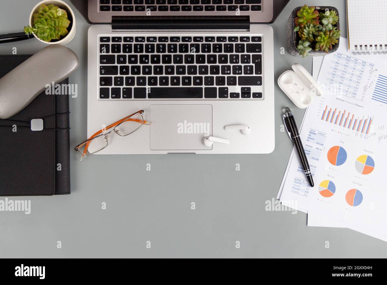 Laptop, documents and modern gadgets on a grey office desk top view ...
