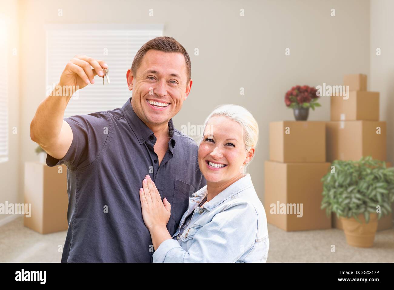 Happy Couple With New House Keys Inside Empty Room with Boxes Stock ...