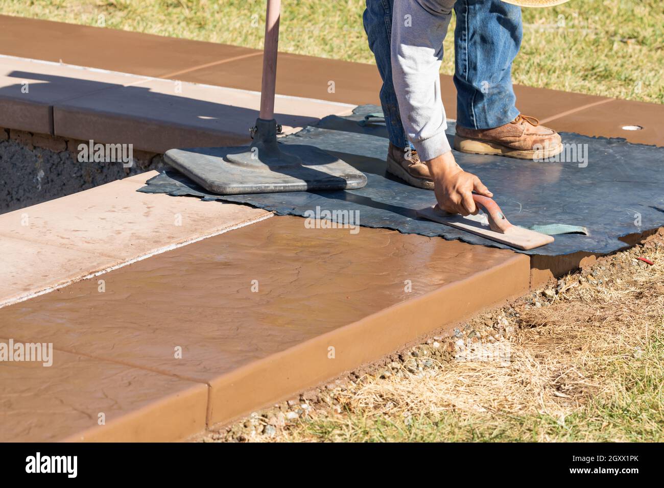 Construction Worker Applying Pressure to Texture Template On Wet Cement ...