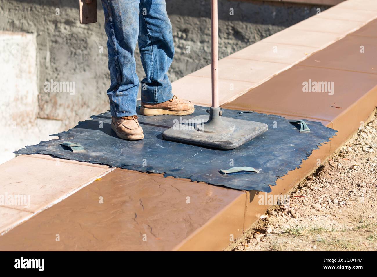 Construction Worker Applying Pressure to Texture Template On Wet Cement ...