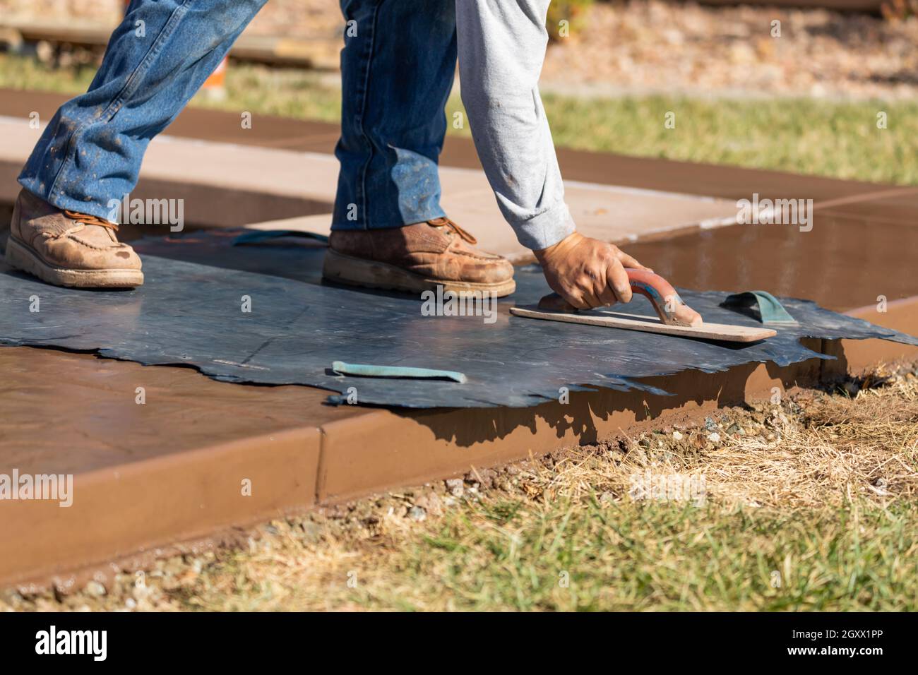 Construction Worker Applying Pressure to Texture Template On Wet Cement ...