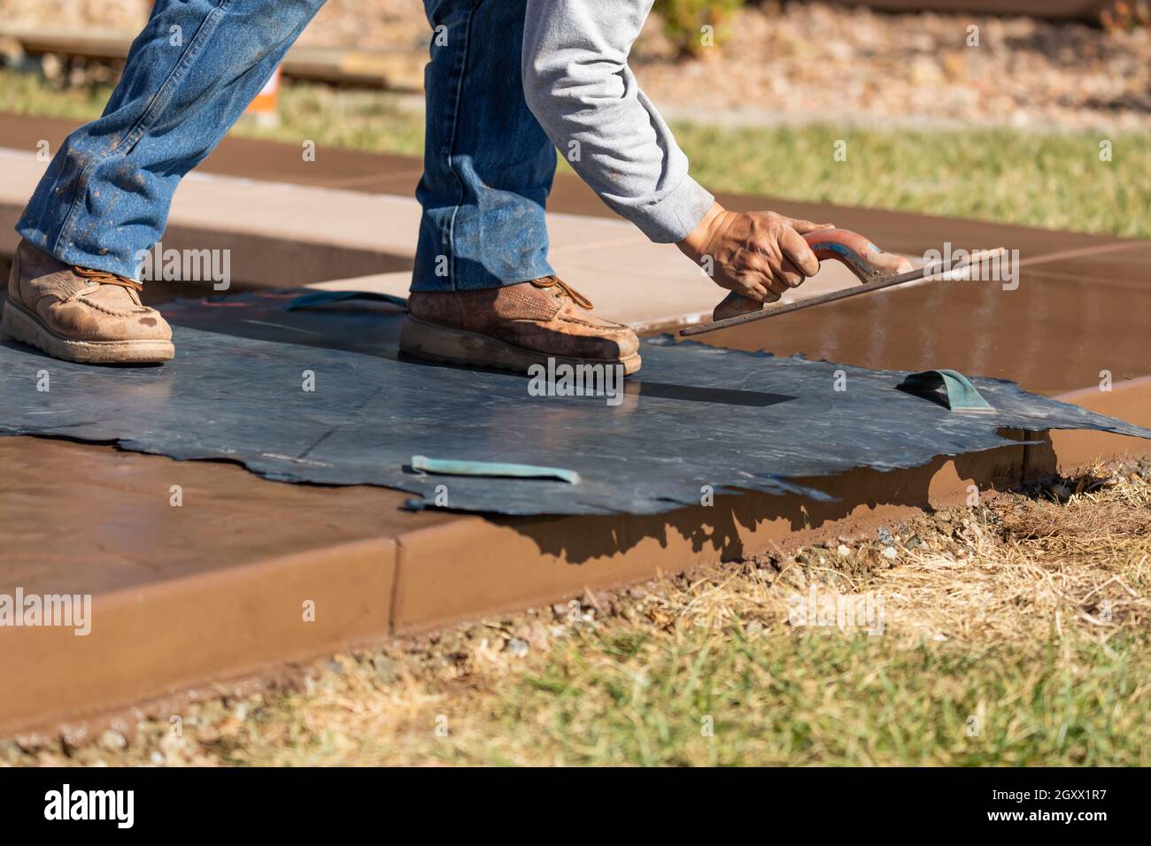 Construction Worker Applying Pressure to Texture Template On Wet Cement ...