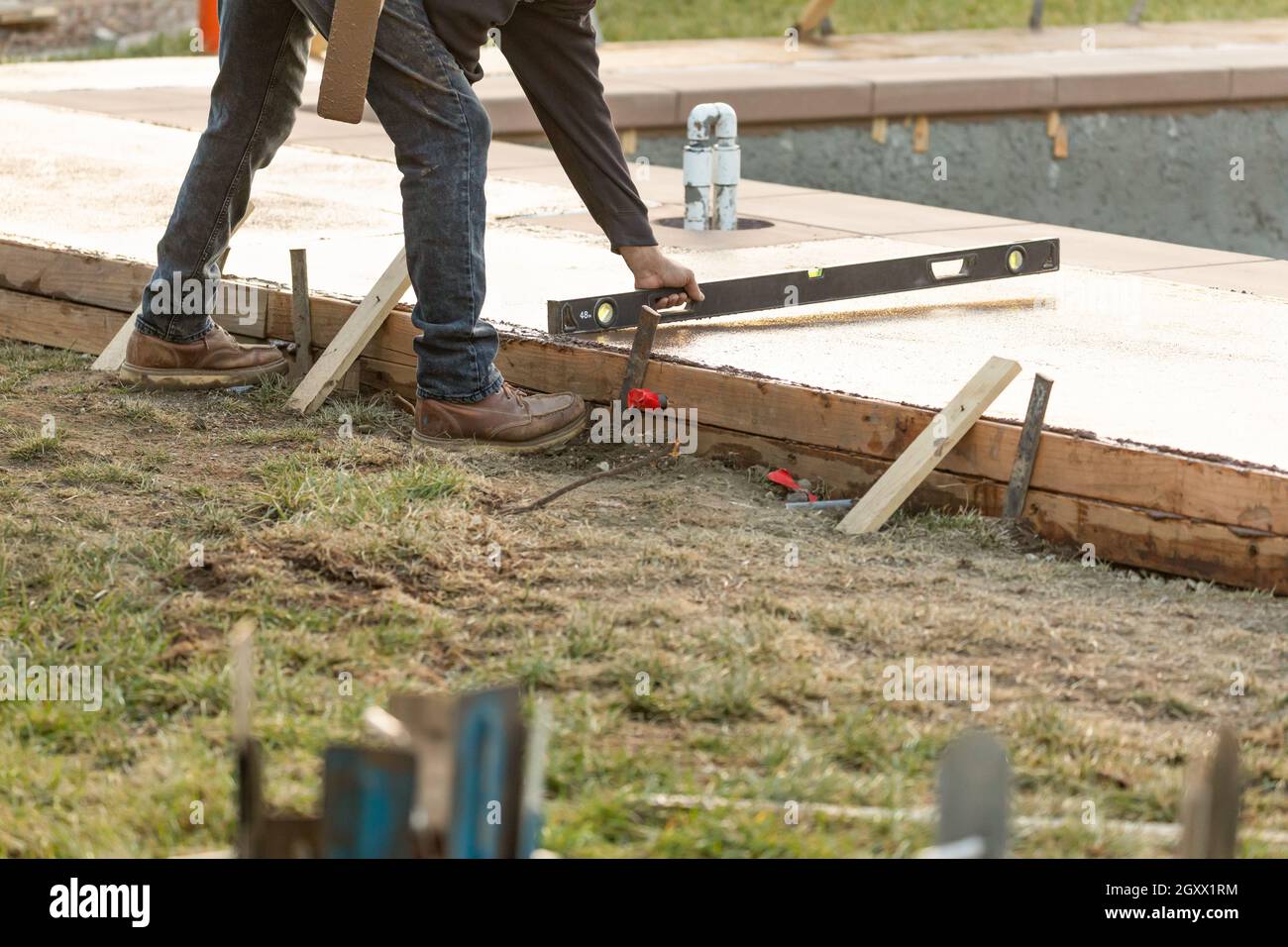 Construction Worker Checking Level On Wet Deck Cement Stock Photo - Alamy