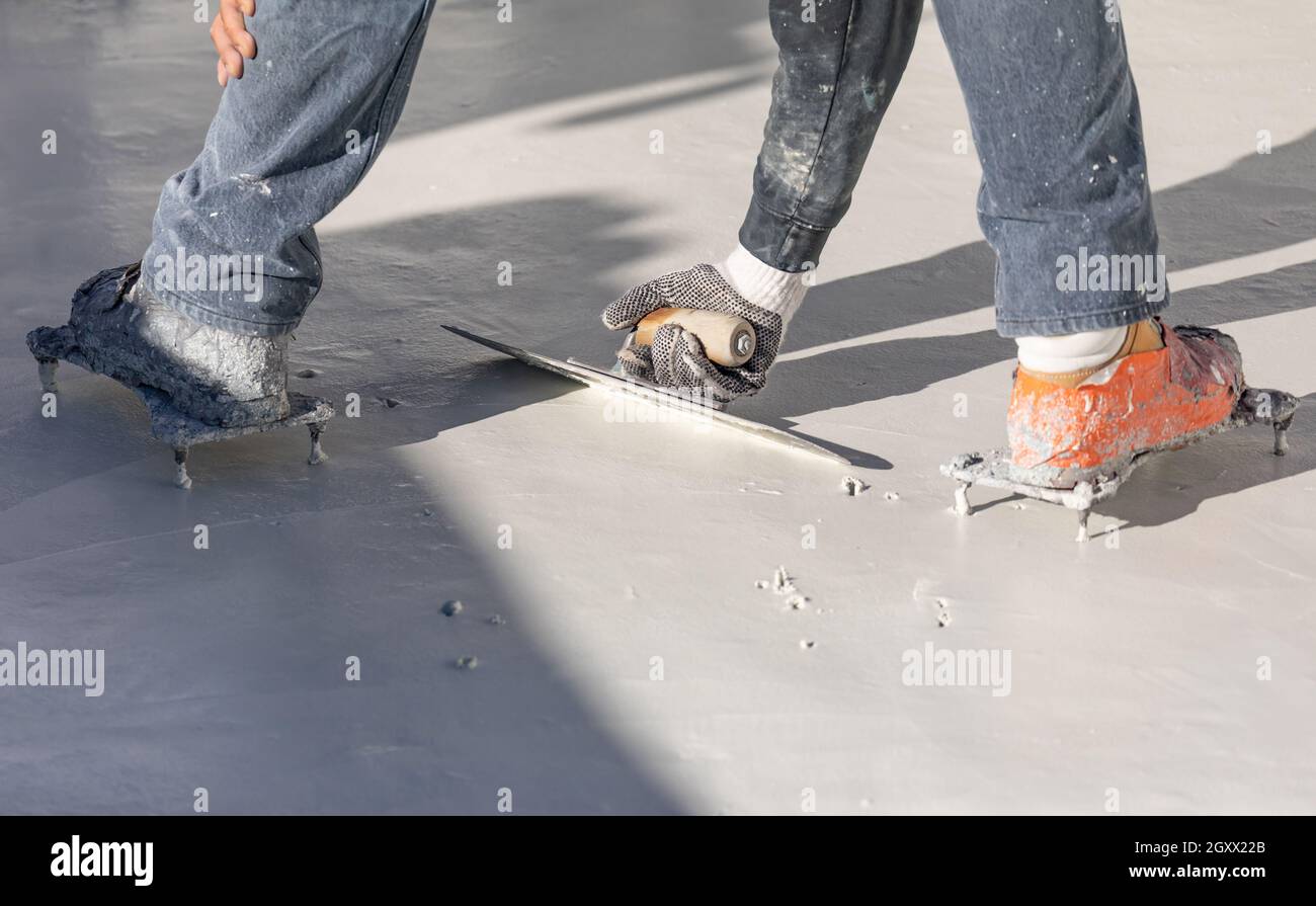 Worker Wearing Spiked Shoes Smoothing Wet Pool Plaster With Trowel ...