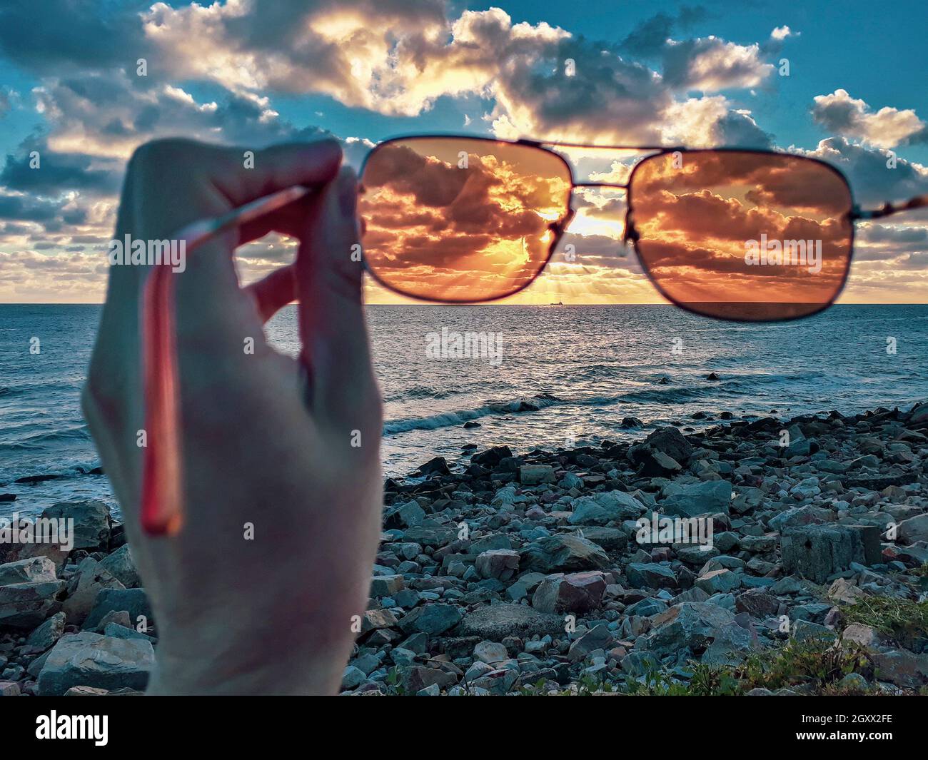 Hand holding sunglasses hi-res stock photography and images - Alamy