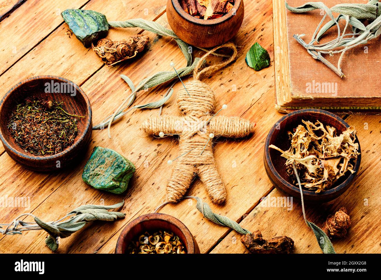 Voodoo doll, magical herbs and witchcraft attributes on an old table ...