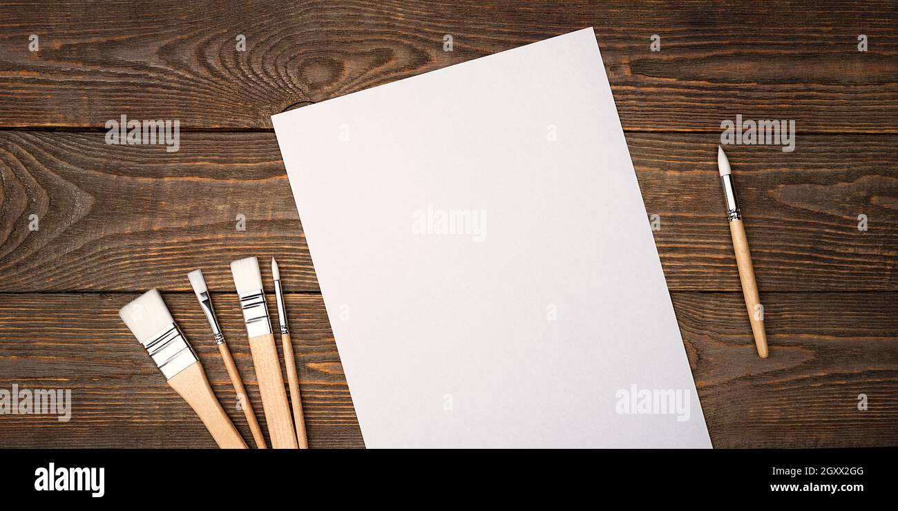 A clean white sheet and brushes on a textured background with space to ...