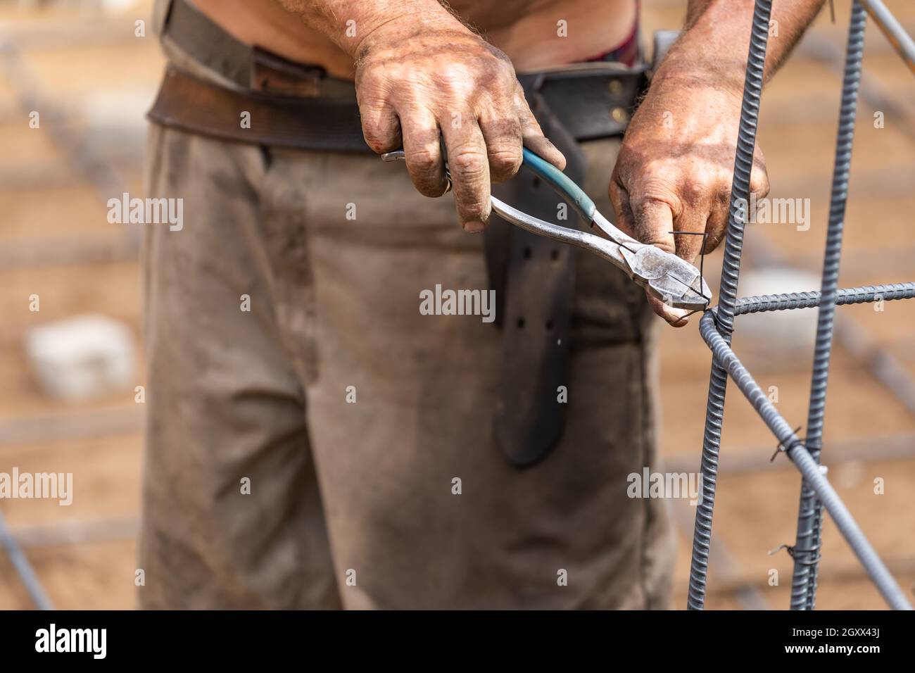 Worker Securing Steel Rebar Framing With Wire Plier Cutter Tool At ...