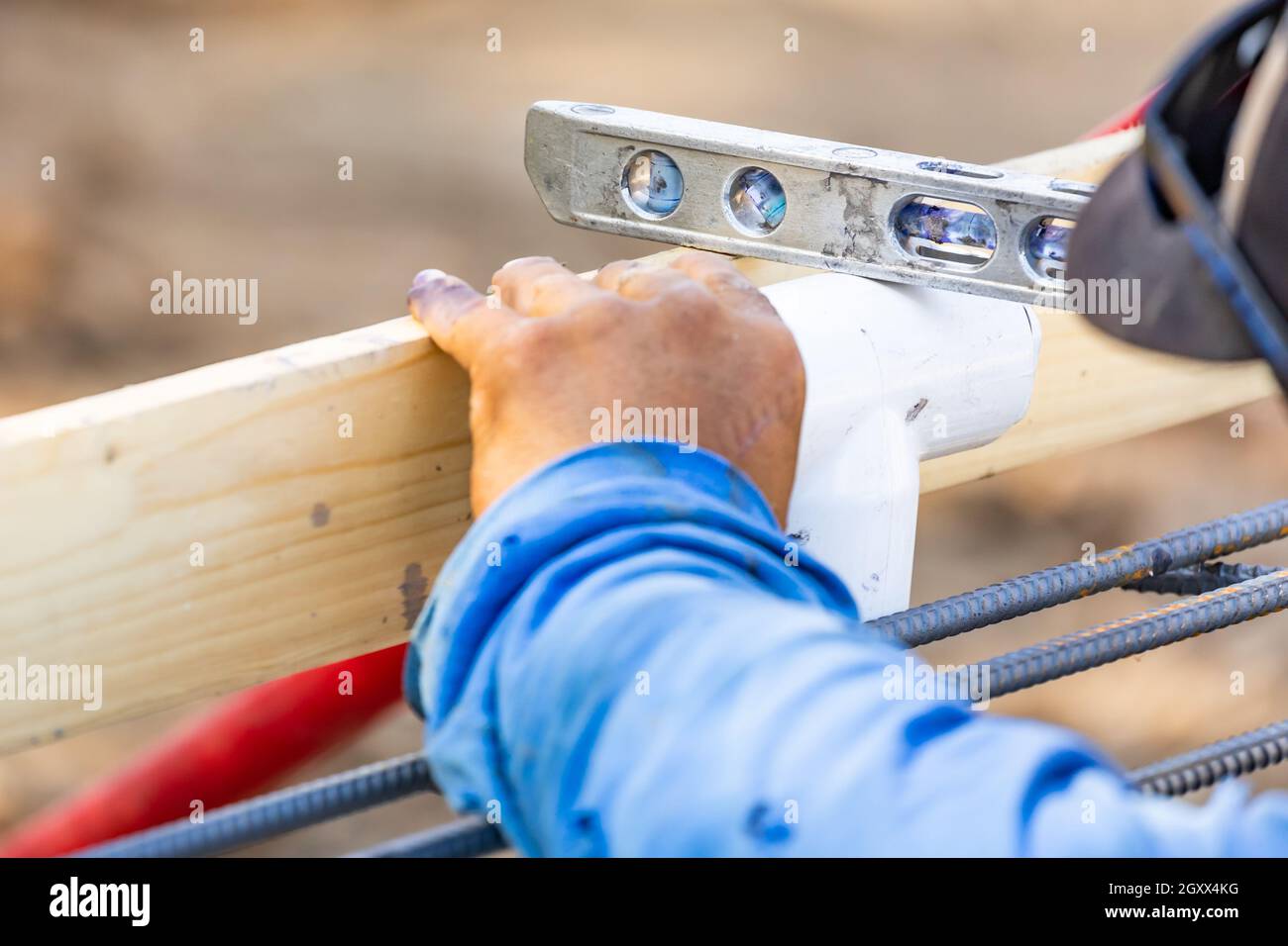 Plumber Using Level While Installing PVC Pipe At Construction Site ...